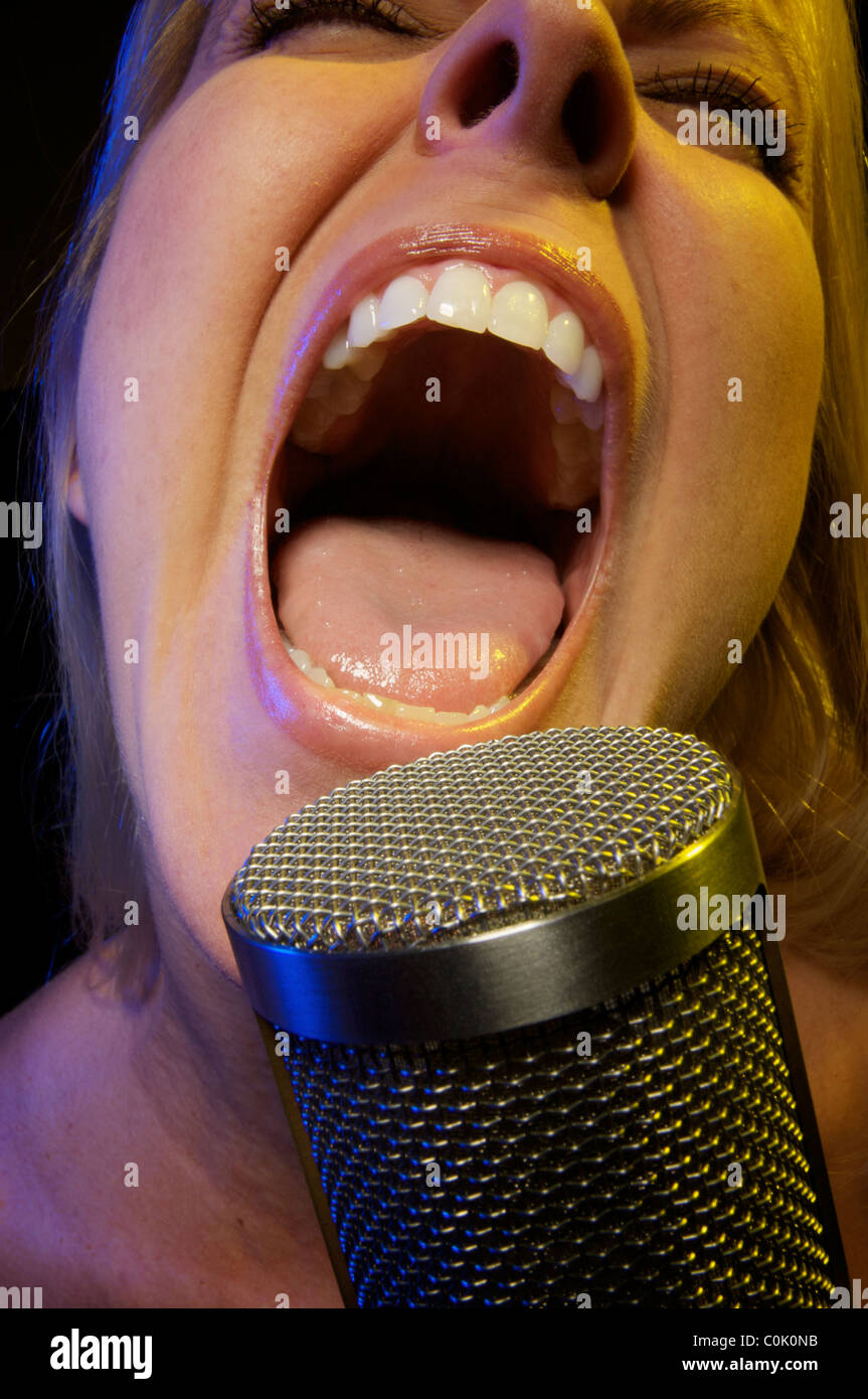 Woman with Microphone Sings with Passion Stock Photo - Alamy