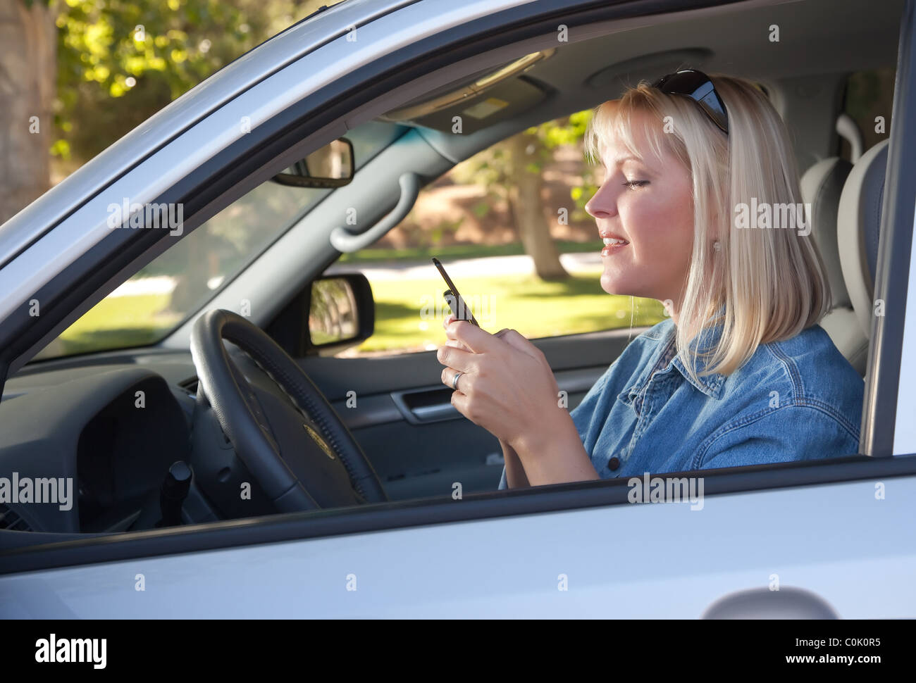 Distracted Blonde Girl Text Messaging on Her Cell Phone While Driving ...