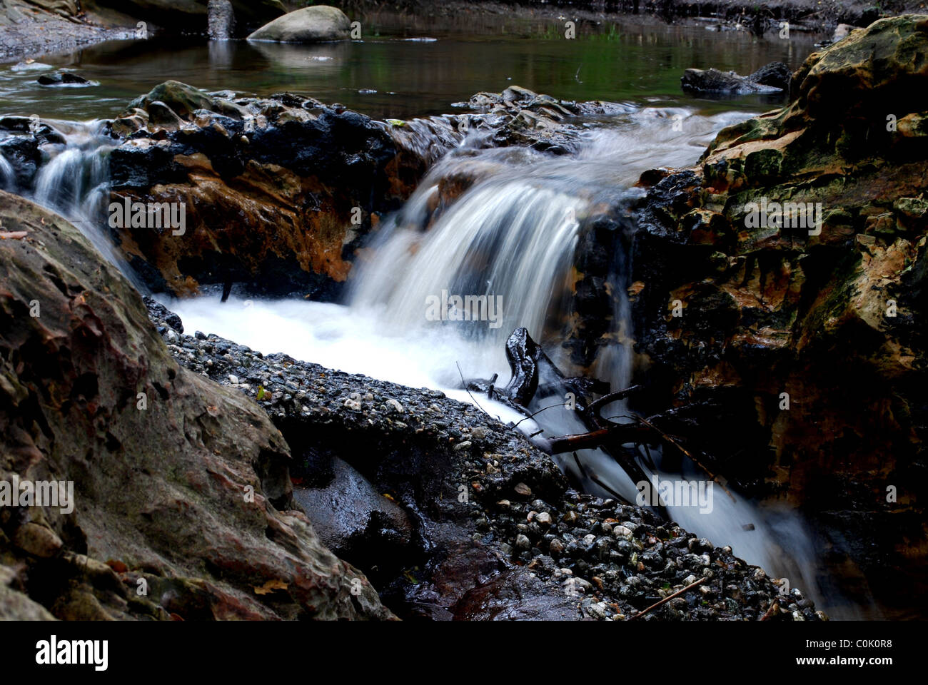 A stream with a small waterfall Stock Photo - Alamy