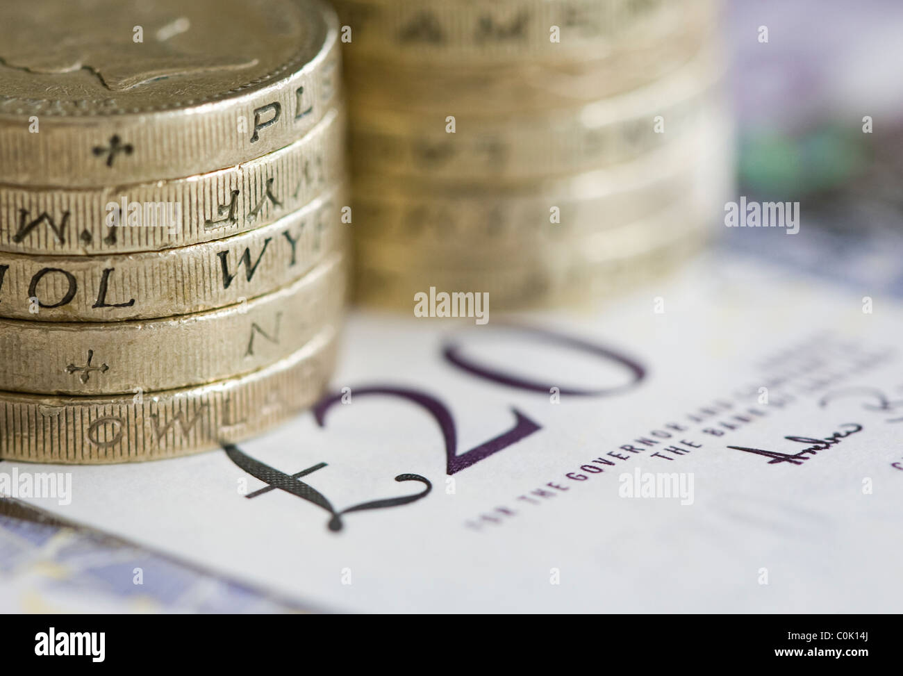 Twenty pound sterling notes and one pound coins are set up for a ...