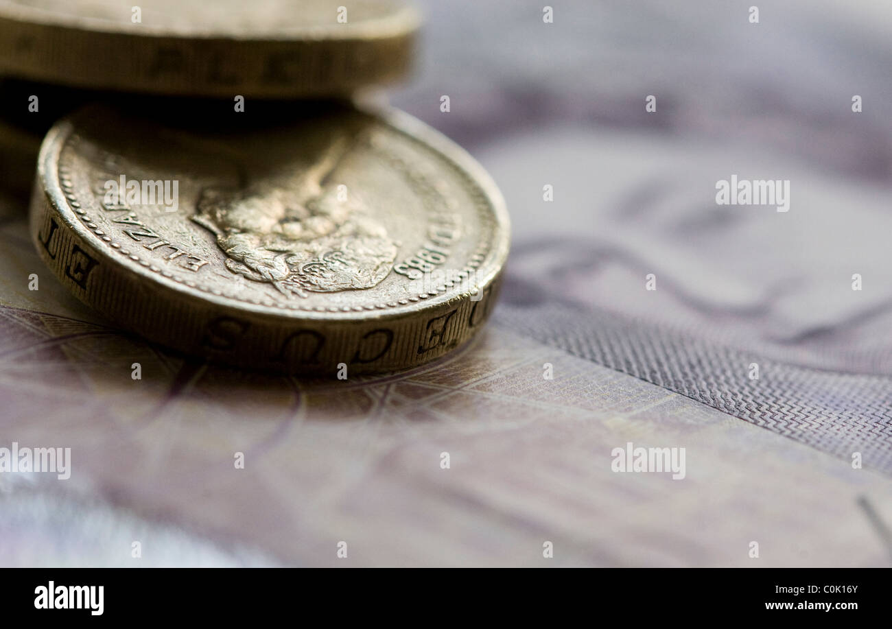 Twenty pound sterling notes and one pound coins are set up for a ...
