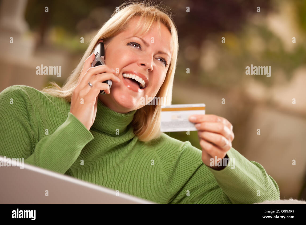 Laughing Woman on Her Phone and Laptop with Credit Card Stock Photo - Alamy