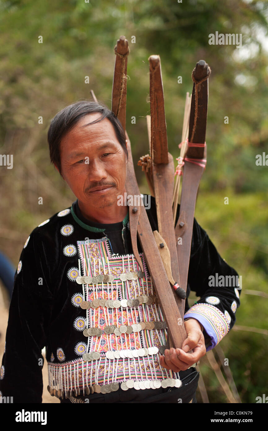 Traditionally dressed Hmong man with three cross bows at a new year ...