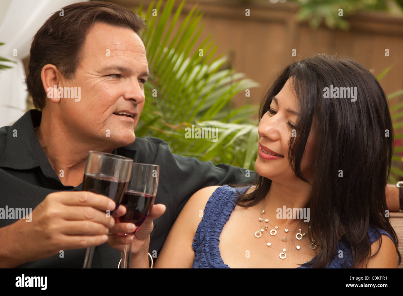 Attractive Hispanic and Caucasian Couple Drinking Wine Outside Stock ...