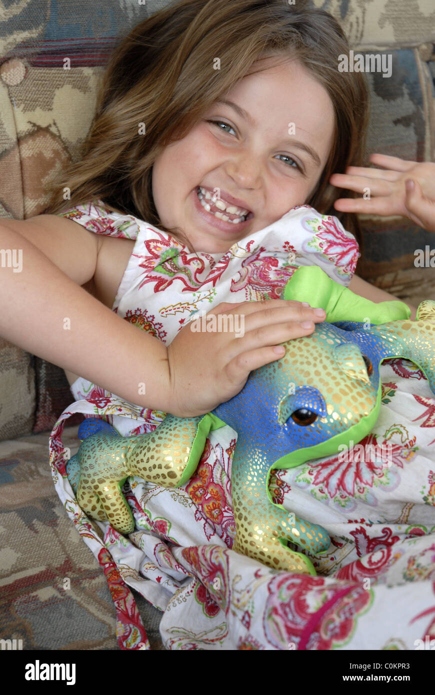 Little girl laughing and holding a toy frog Stock Photo - Alamy