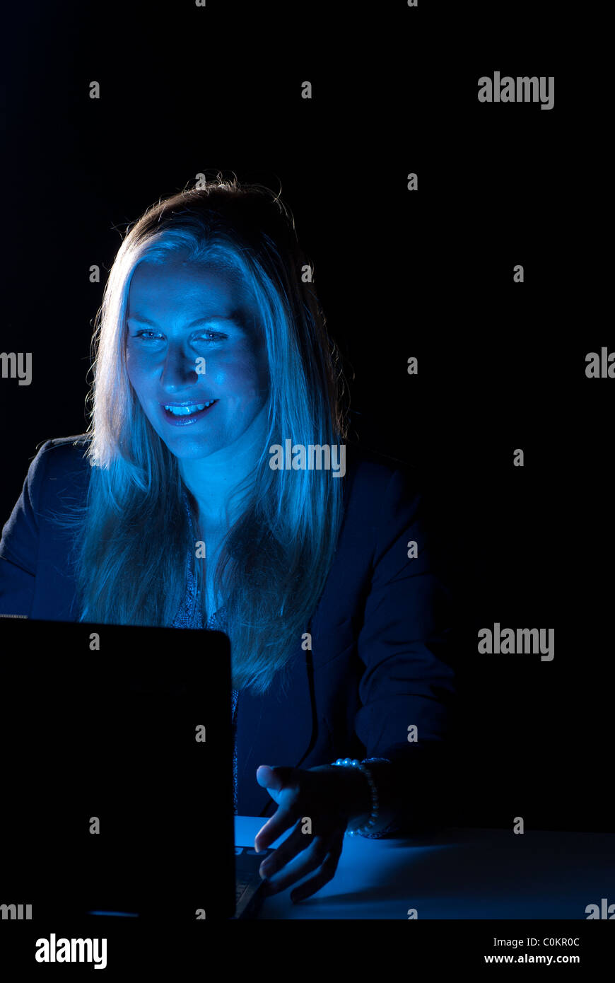 Businesswoman working late hours, with positive, smiling attitude Stock ...