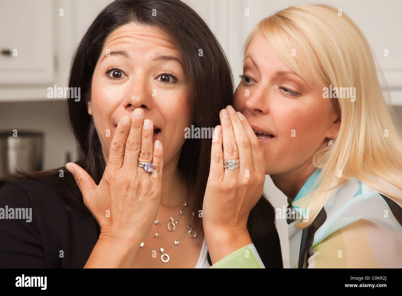 Women whispering in friends ear hi-res stock photography and images - Alamy