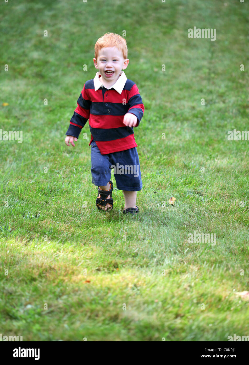 Happy boy running down hill Stock Photo - Alamy