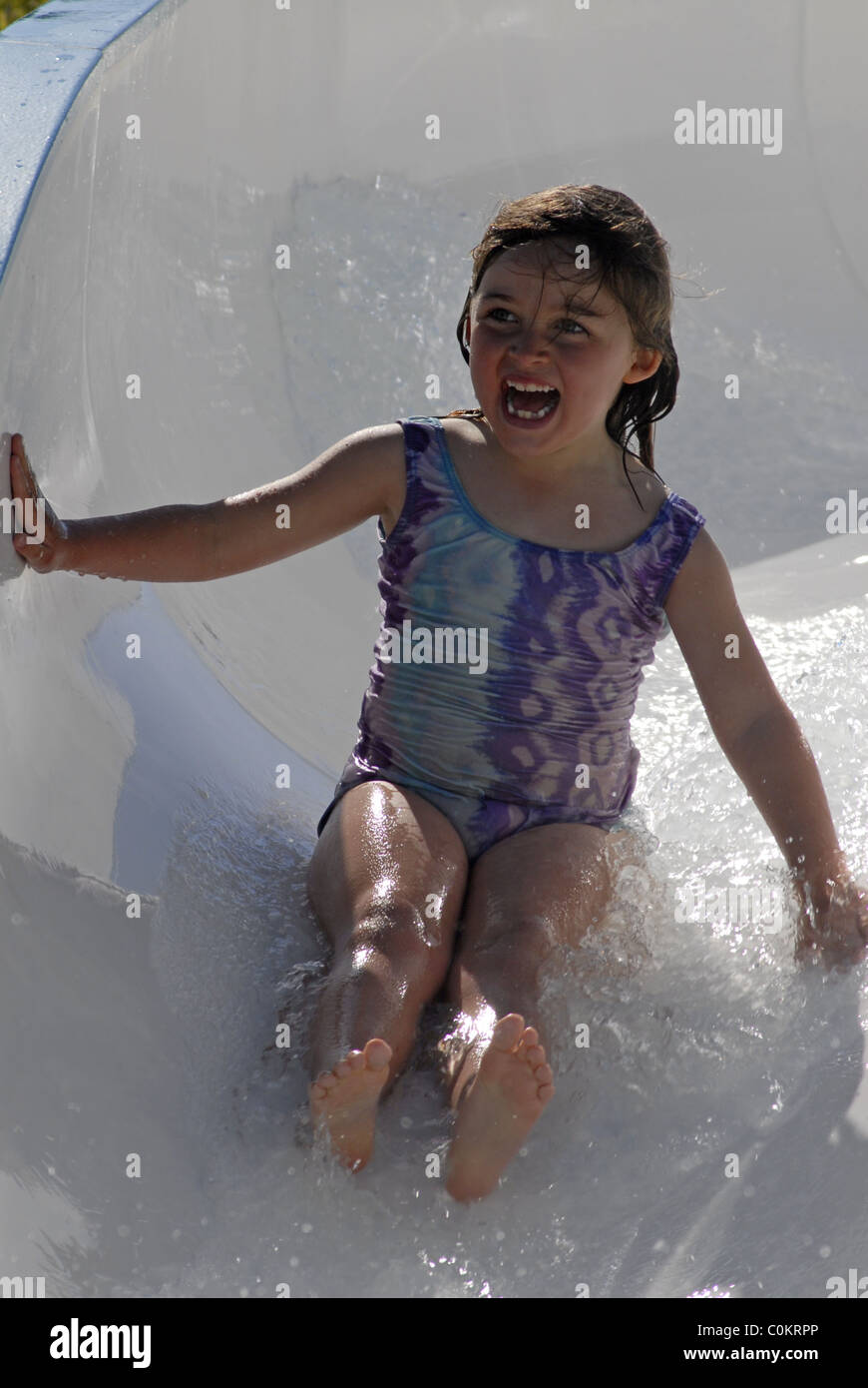 Little girl sliding down a water slide Stock Photo - Alamy