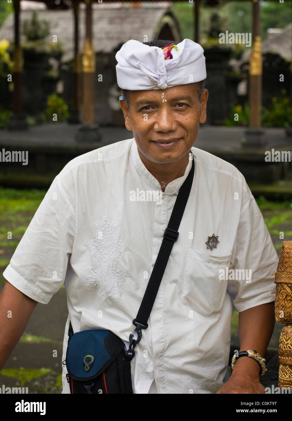 A Balinese man in traditional dress attends a Hindu full moon ceremony ...