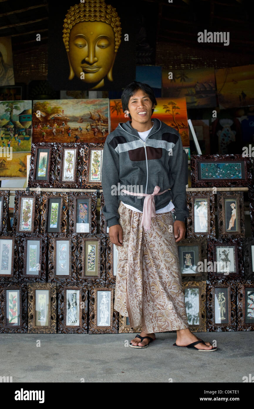 An artist at the Hindu temple, Besakih, Bali, displays his artwork for ...