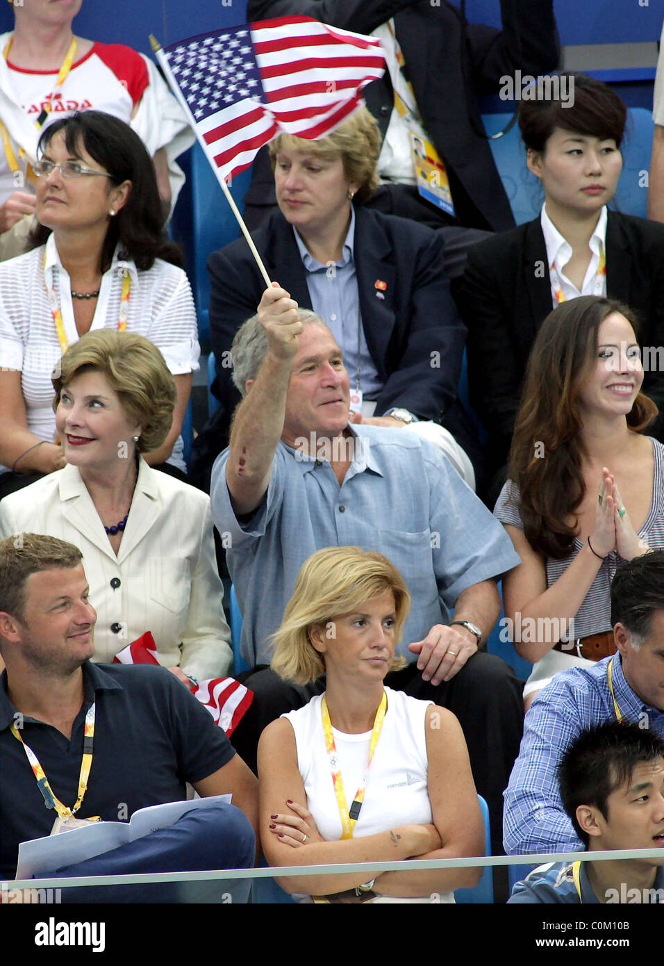 President George W. Bush waves the American flag and cheers athletes at ...