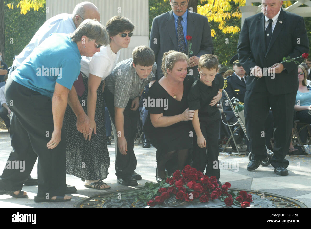 The bereaved hold their rose before placing on the National Law ...