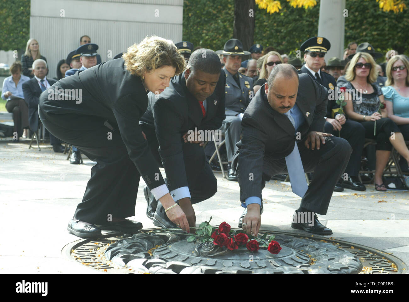 The bereaved hold their rose before placing on the National Law ...