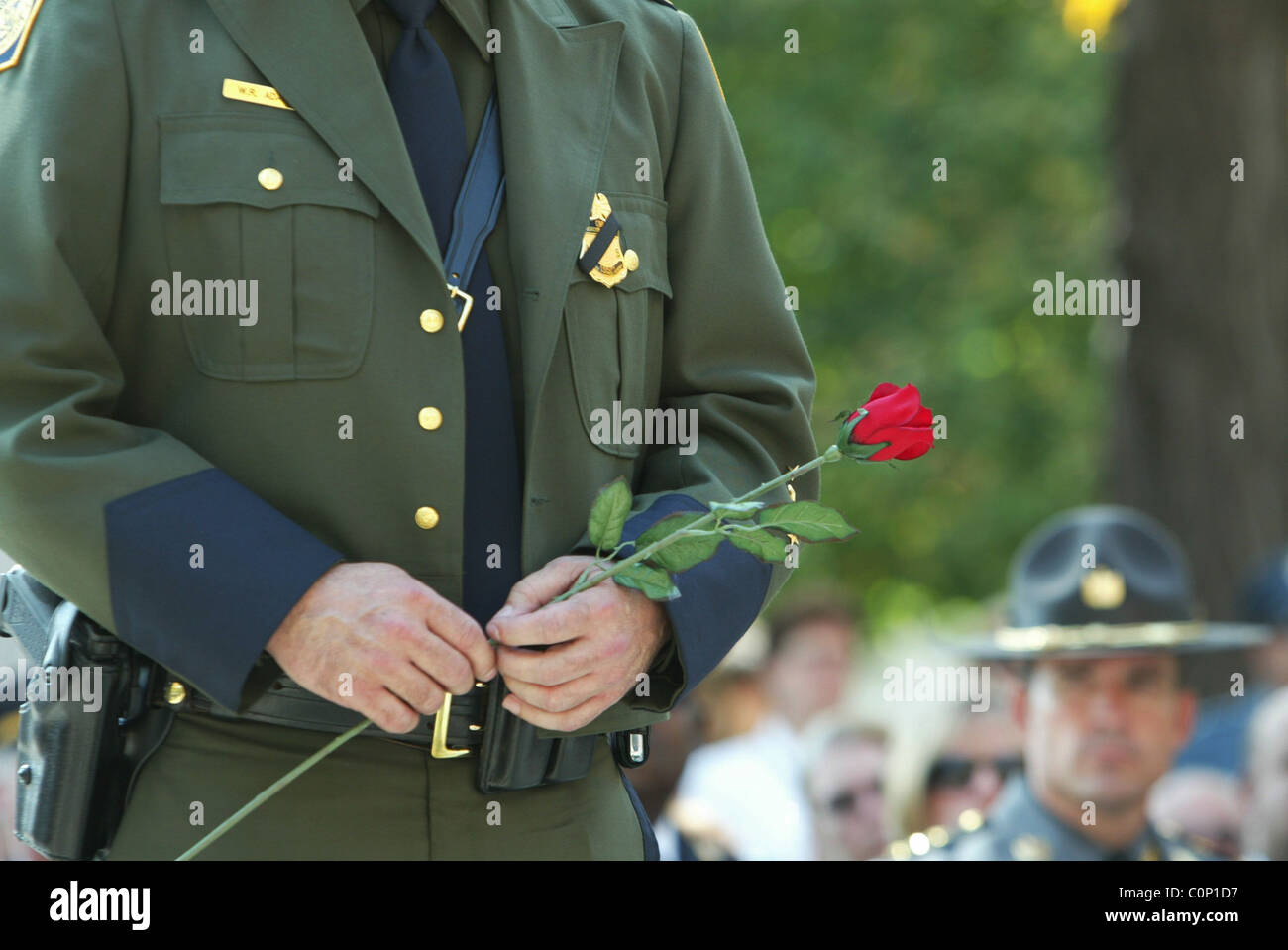 The bereaved hold their rose before placing on the National Law ...