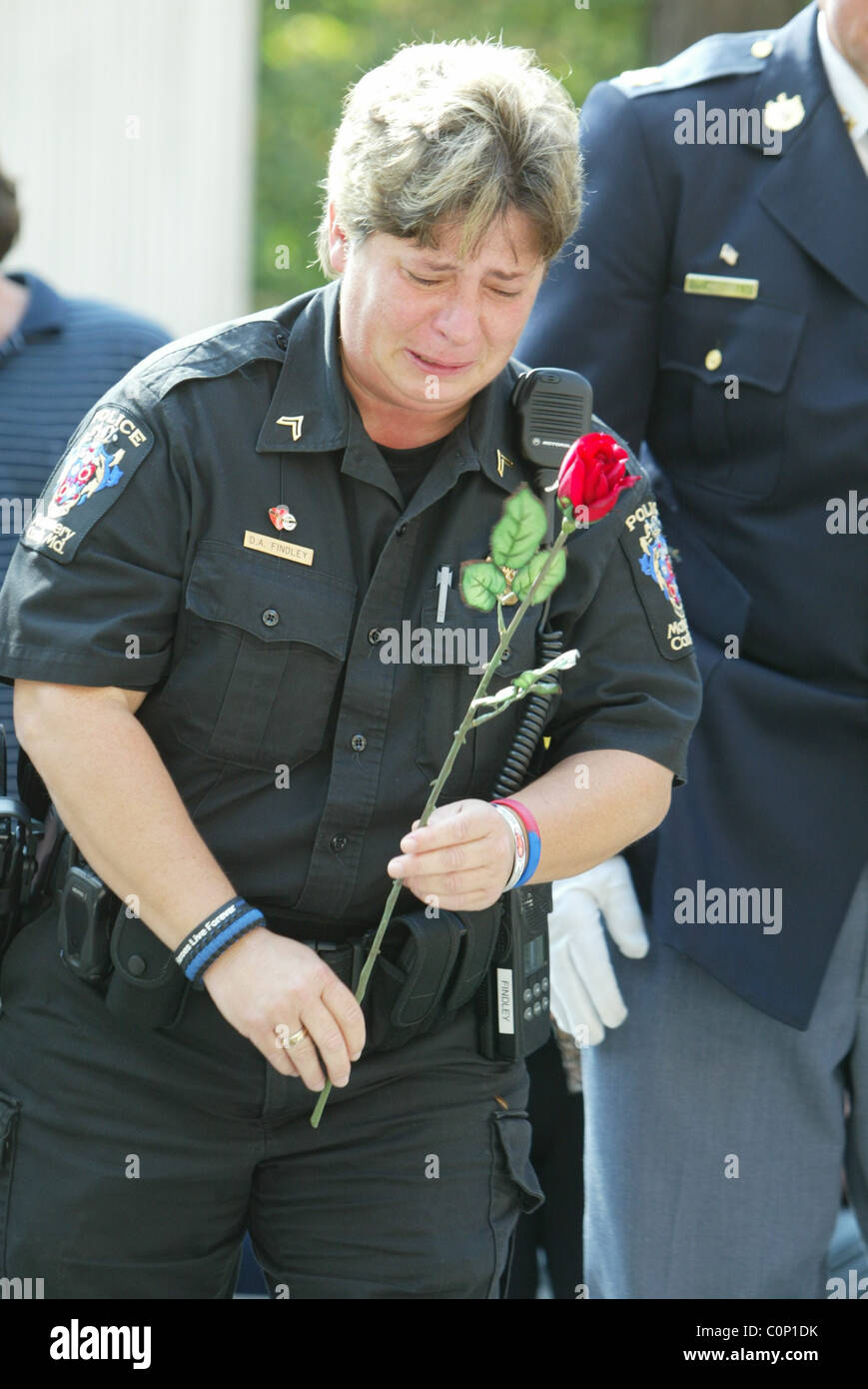 The bereaved hold their rose before placing on the National Law ...