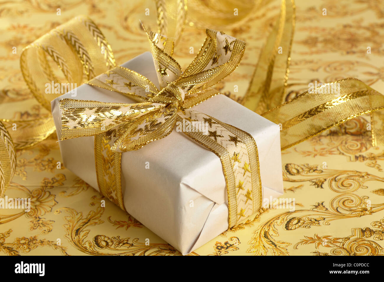 Beautiful gift box on the gold background Stock Photo - Alamy