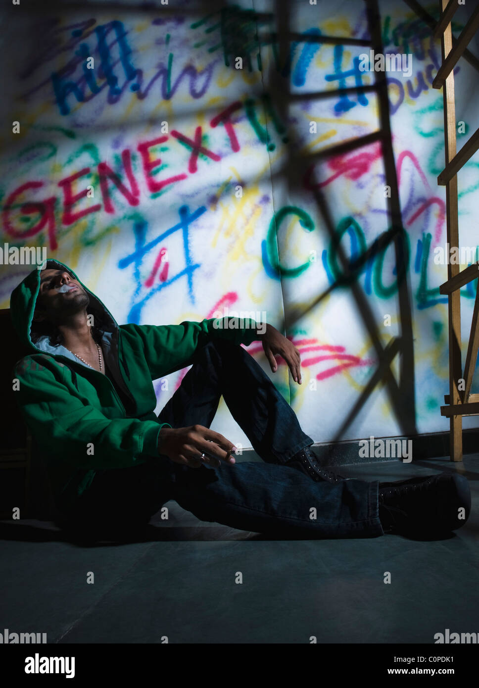 Man smoking in front of a graffiti covered wall Stock Photo - Alamy