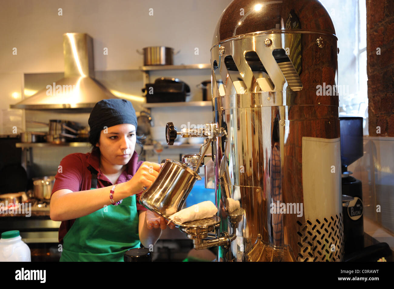 Young female Barista frothing milk on an exotic espresso machine Stock ...