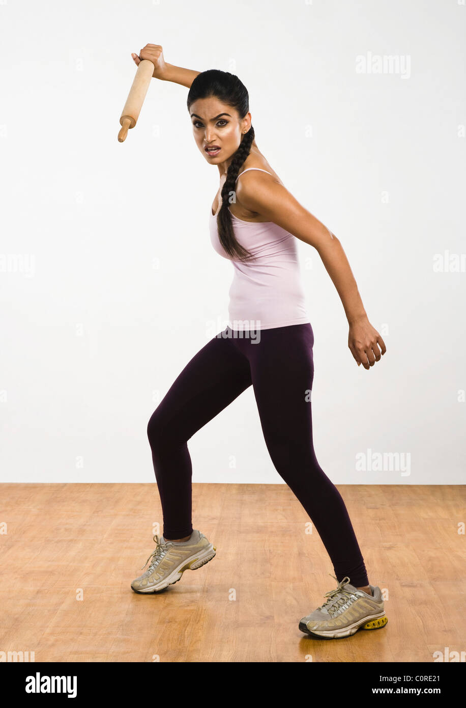 Woman holding a rolling pin and standing in fighting stance Stock Photo ...