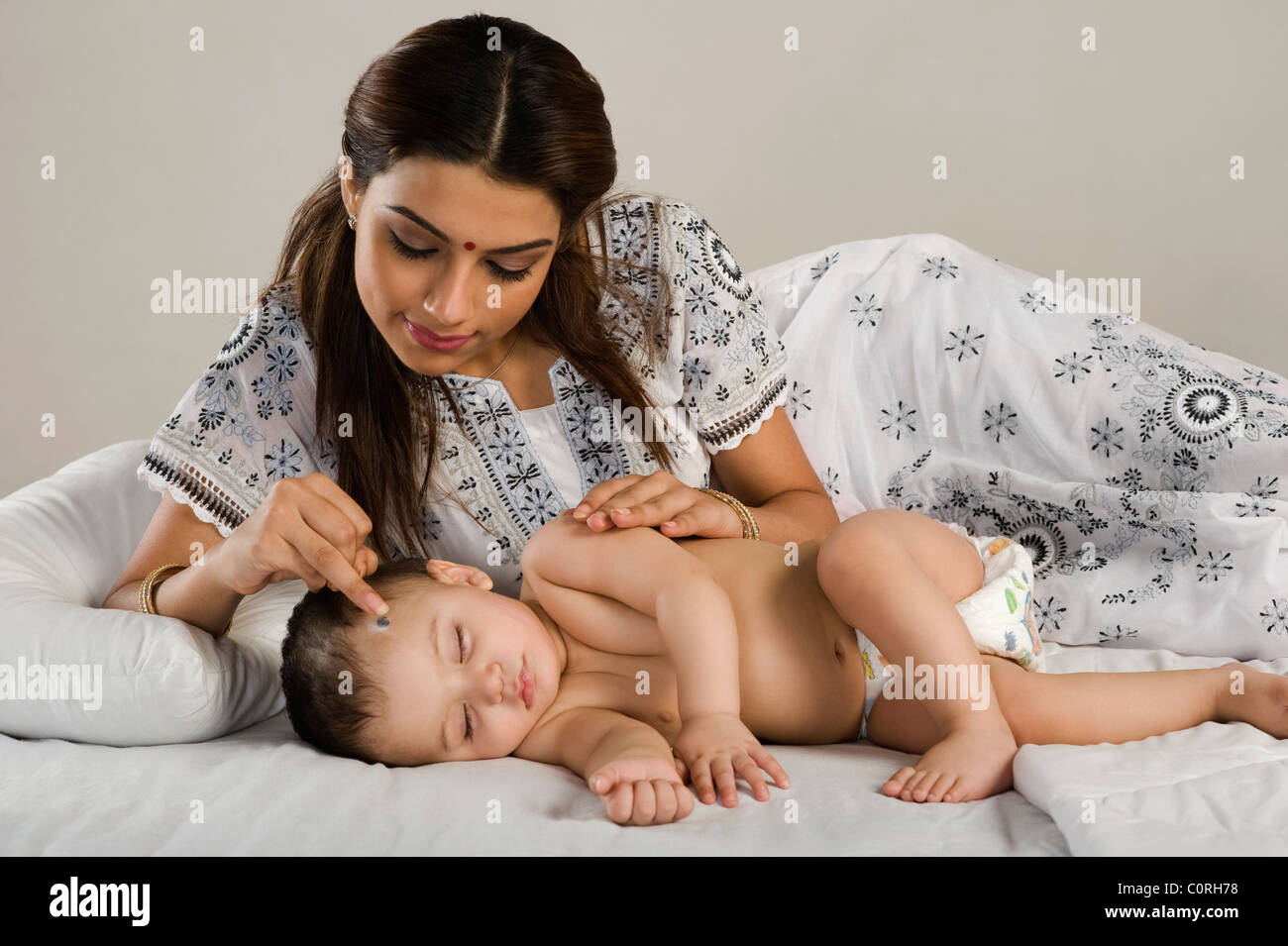 Woman applying kala tika on her son Stock Photo - Alamy