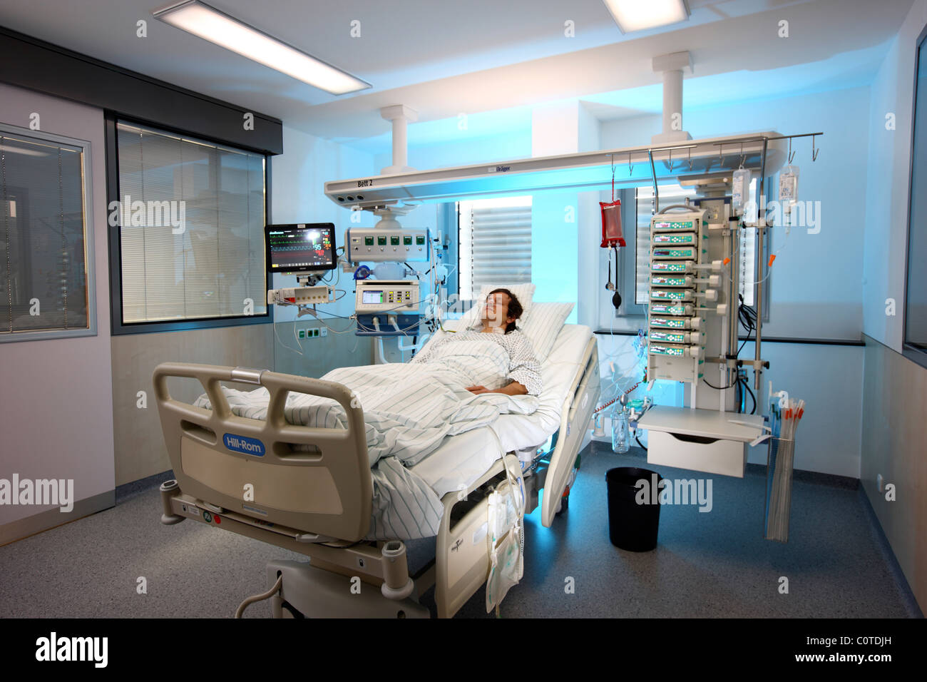 Intensive care unit in a hospital. A patient is connected to different ...