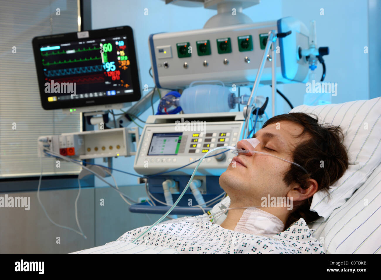 Intensive care unit in a hospital. A patient is connected to different ...
