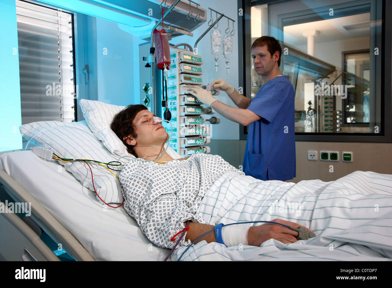 Intensive care unit in a hospital. A patient is connected to different ...