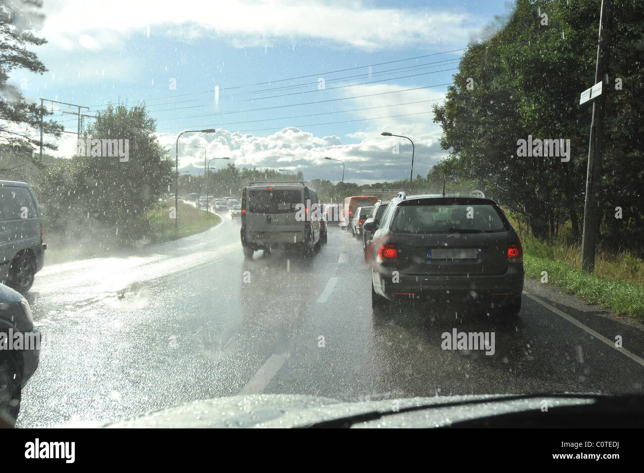 A rainy day on the road. Traffic in the rain. Back-lit Stock Photo - Alamy