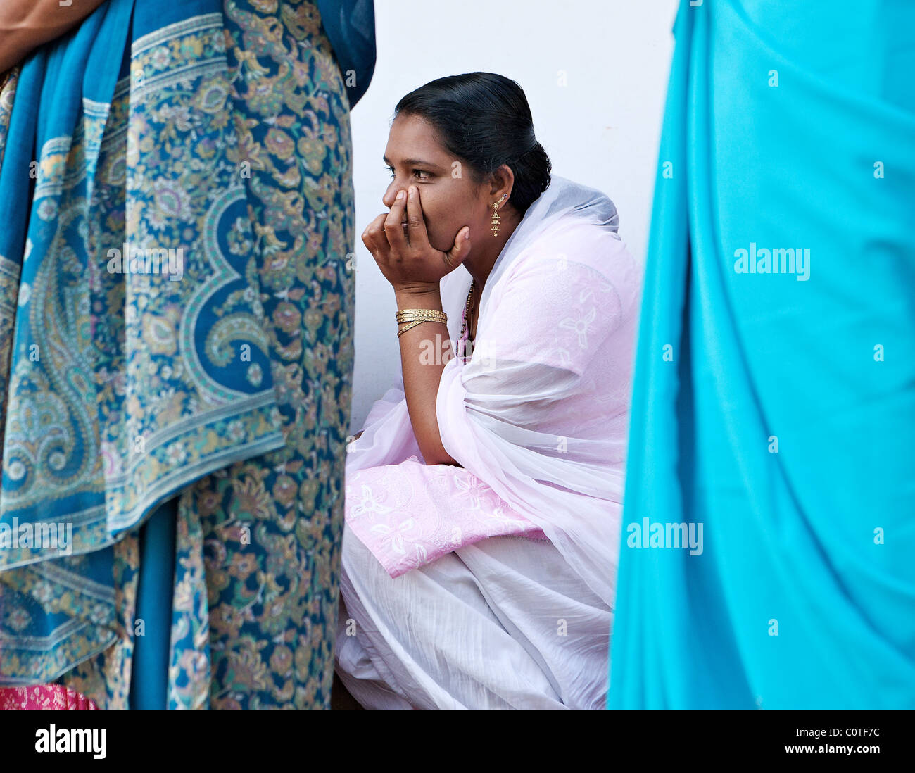 A Keralite Woman Sits Outside A Crowded Church In A Village Outside