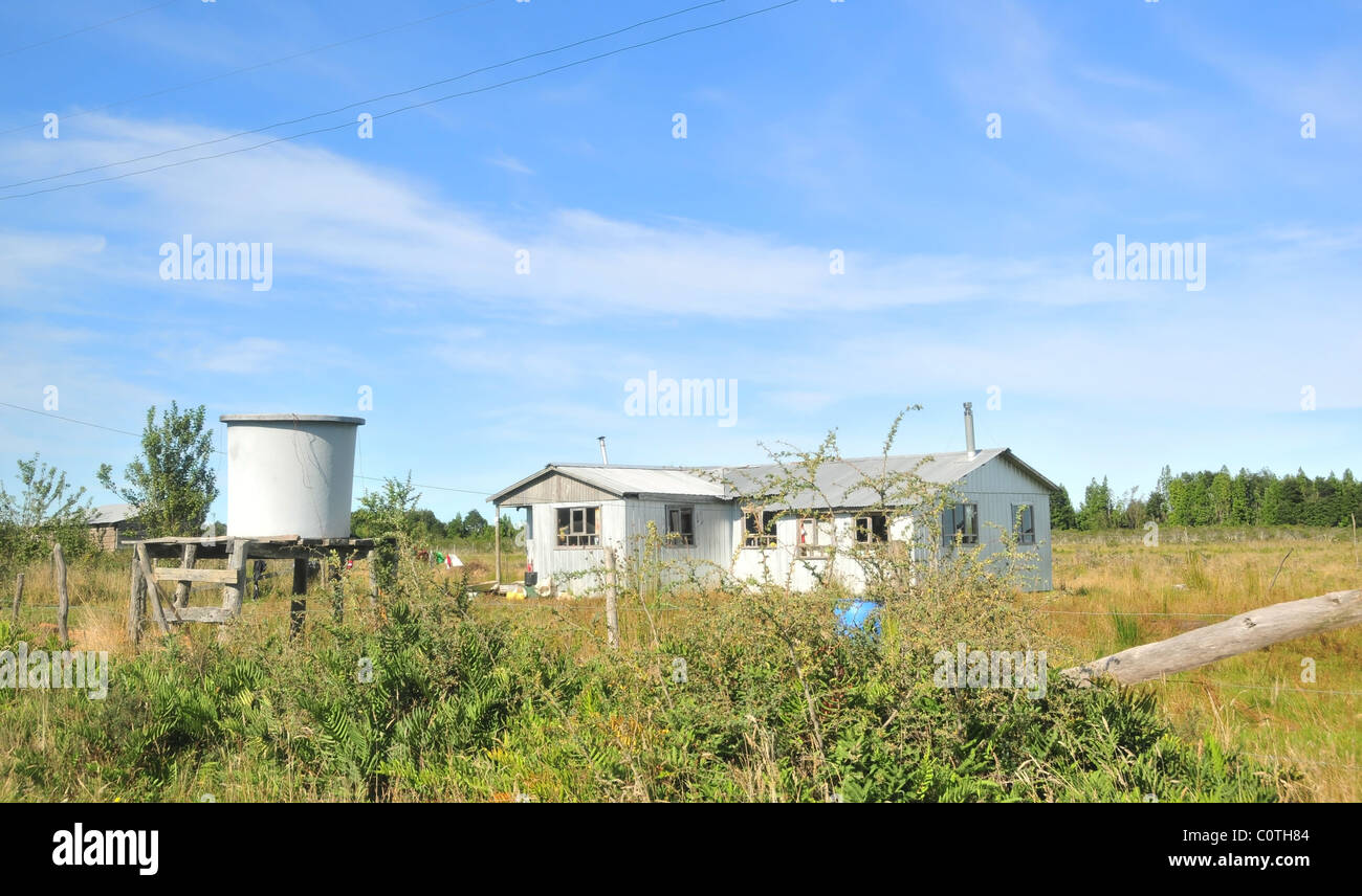 Groundwater collection bucket on a wood tower near a metal bungalow ...