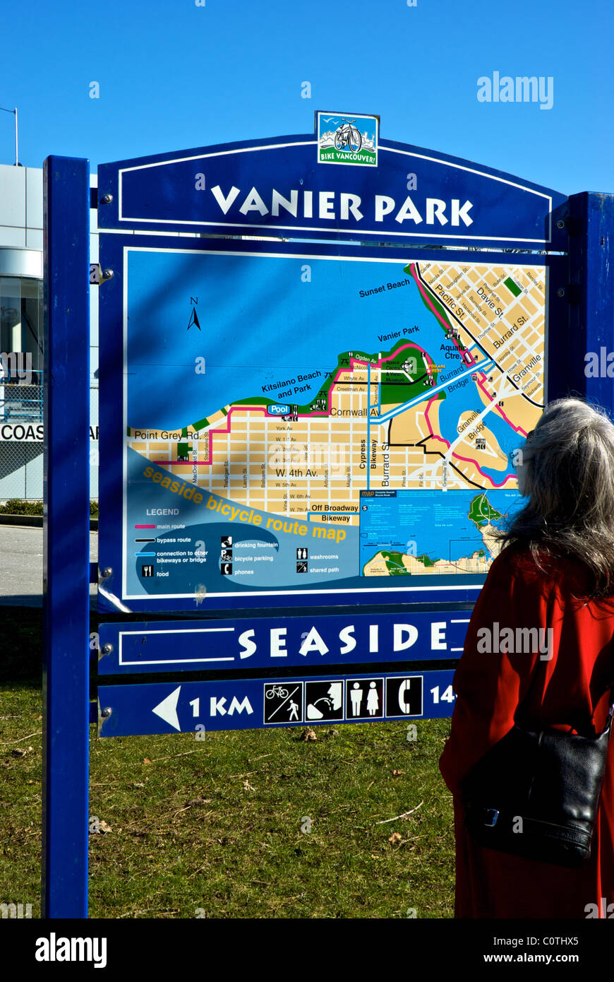 Woman red coat looking at Vancouver Vanier Park bicycle path map Stock ...