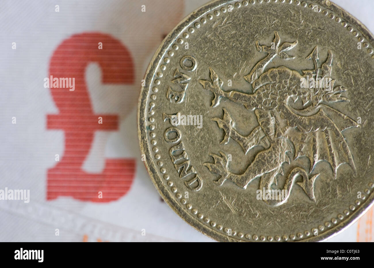 Ten pound sterling notes and one pound coins are set up for a ...