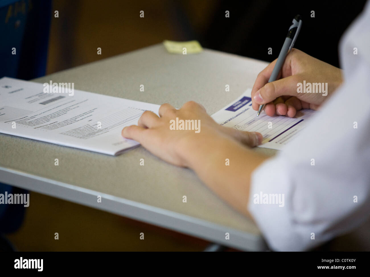 A pupil fills in an answer booklet of a GCSE exam at Maidstone Grammar ...