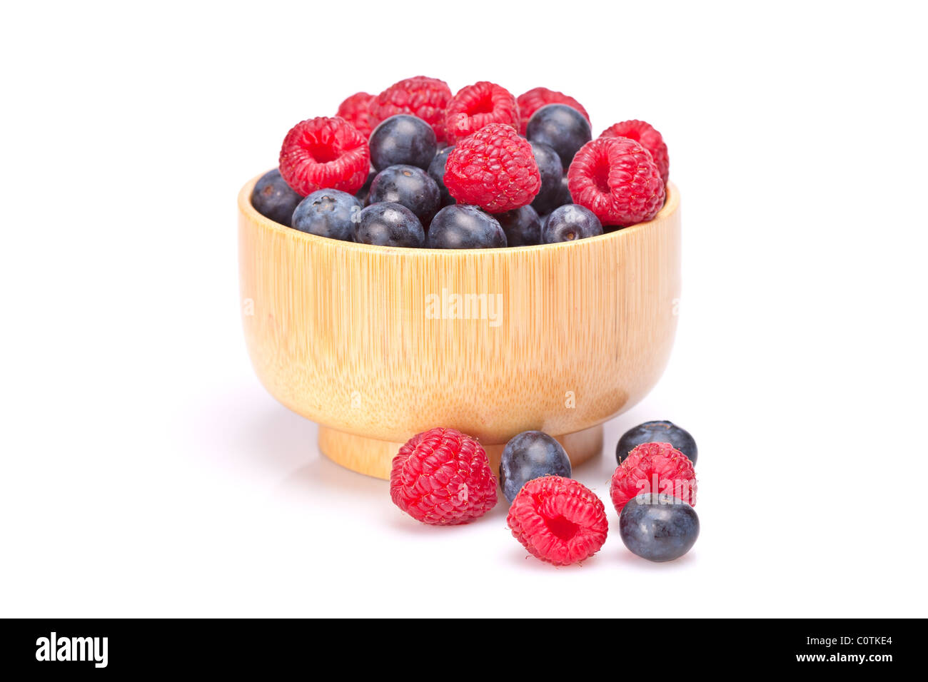Blueberries and raspberries in a bowl with soft shadow on white ...