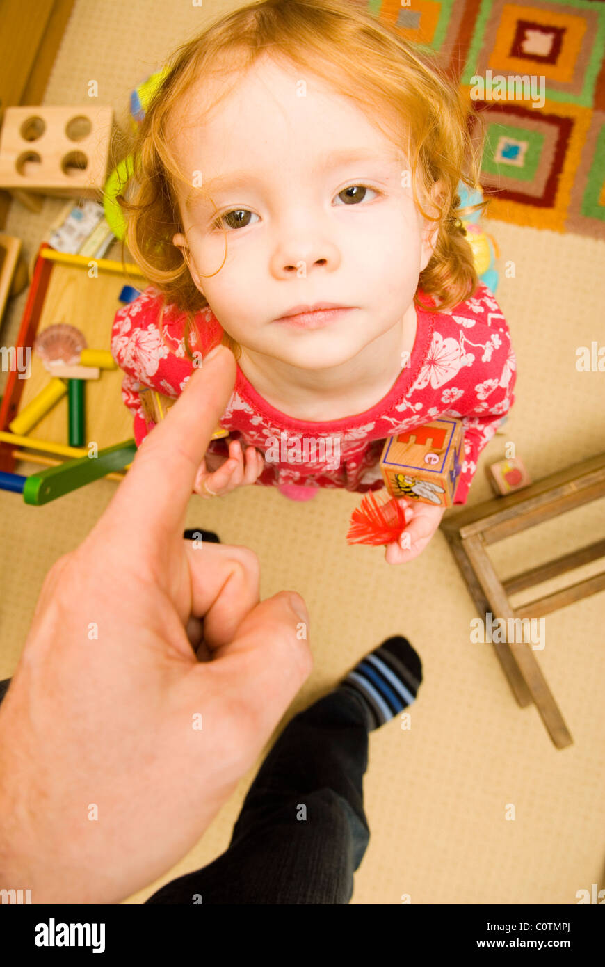 Looking down on a preschool child being told off for misbehaving Stock ...