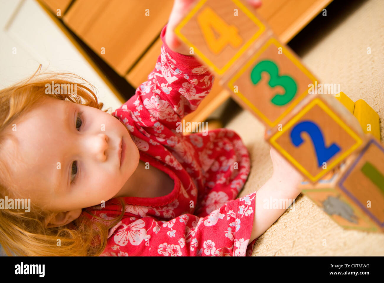 Preschool female child with numbered blocks used for educational ...