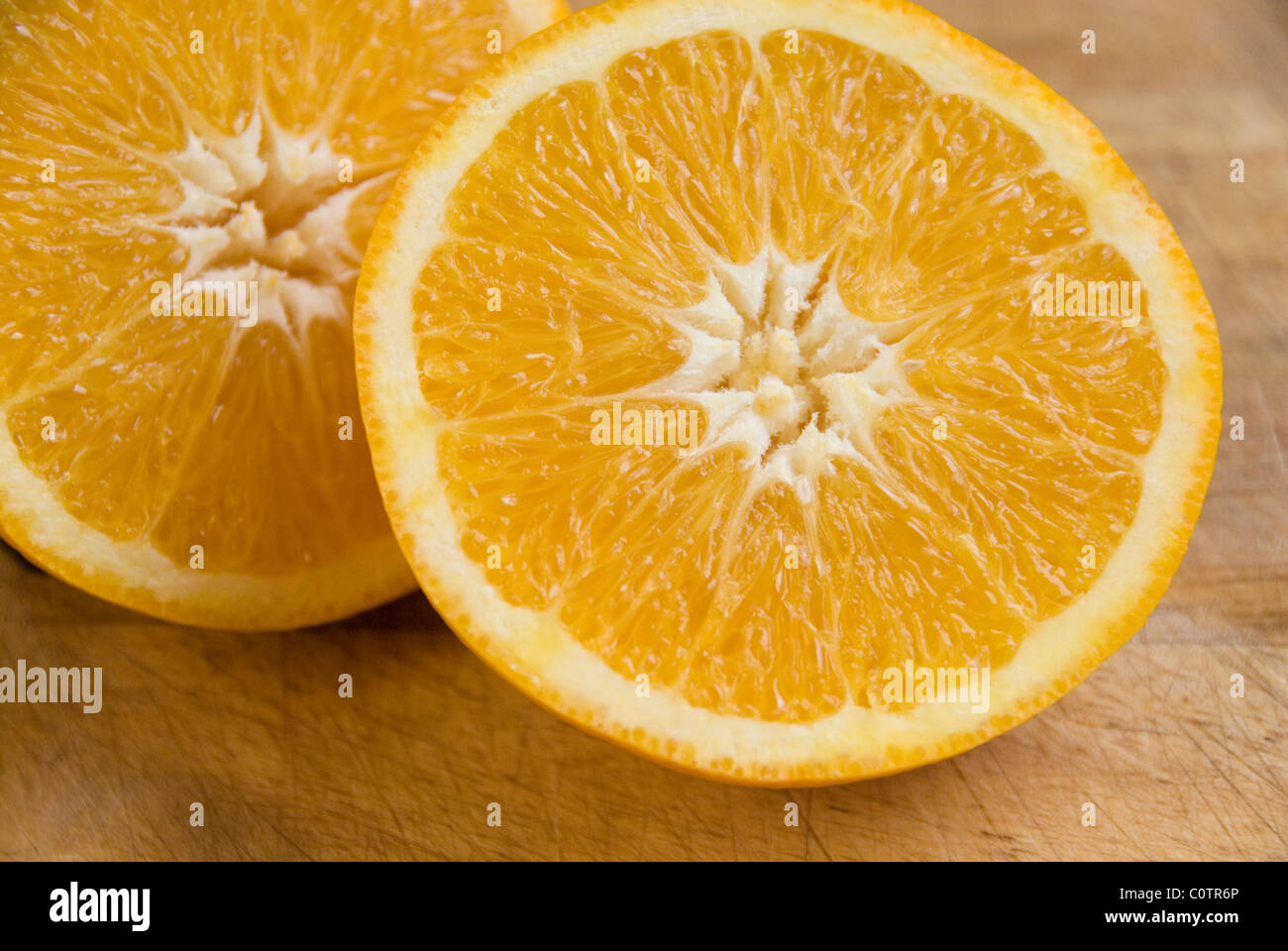 Close up on Two Halves of a Cut Orange on a Wooden Chopping Board Stock ...