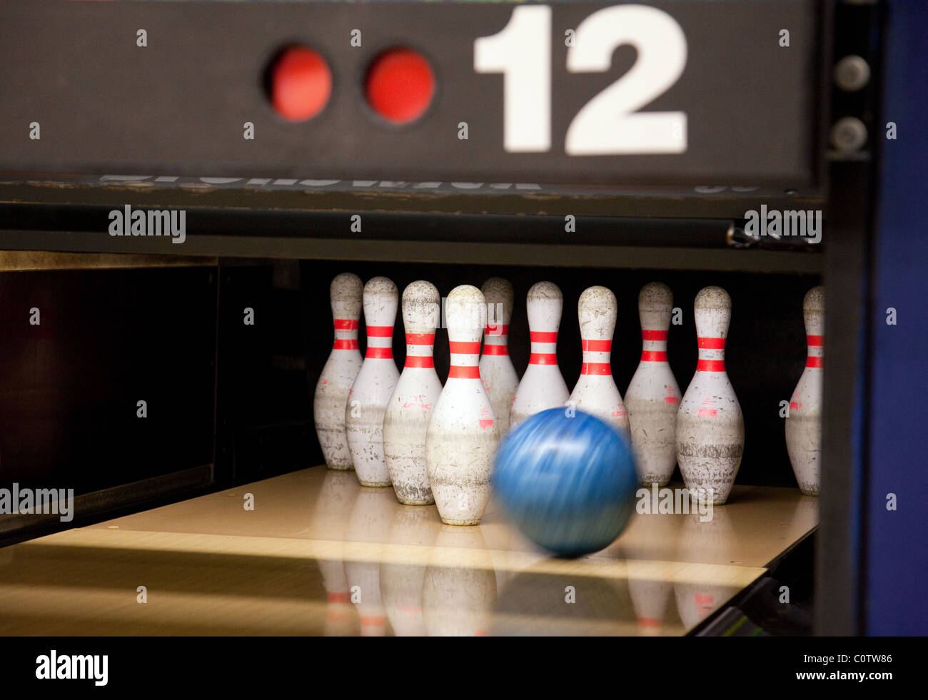 A bowling ball about to hit skittles in a ten-Pin bowling alley ...