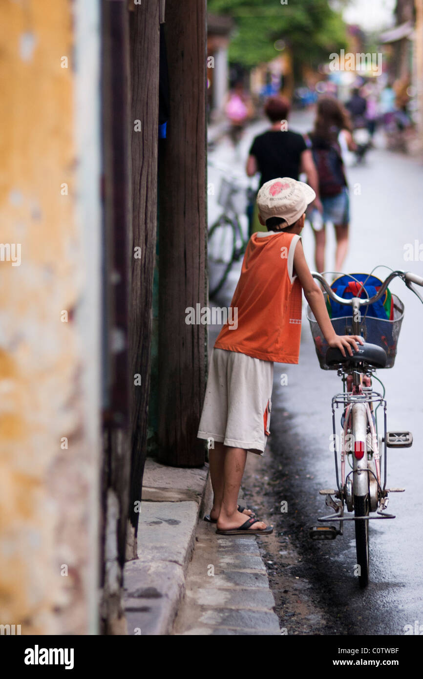 Boy with a bicycle looking at the street in Hoi Ann, Vietnam Stock ...