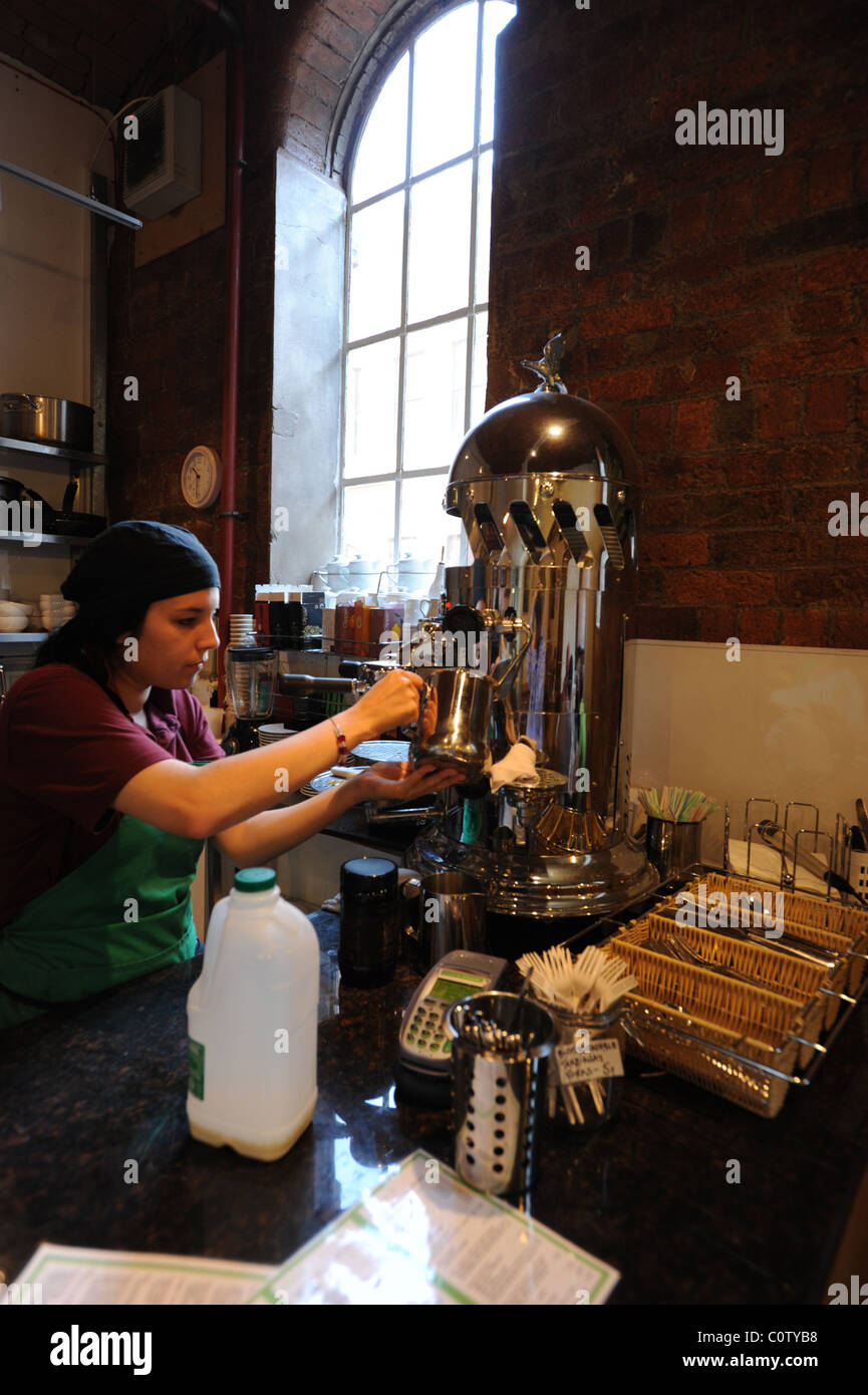 Young female Barista frothing milk on an exotic espresso machine Stock ...