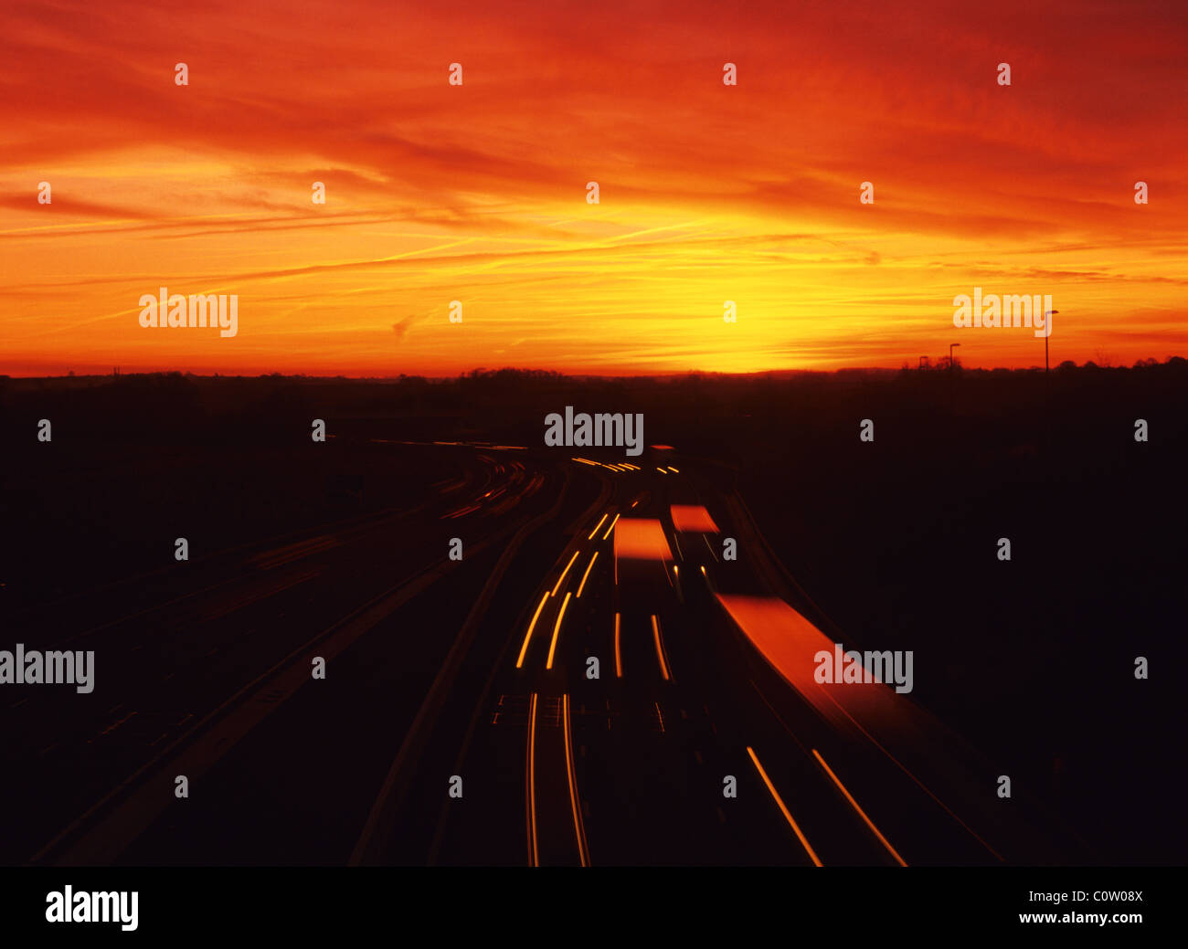 headlight trails of traffic travelling on the A1/M motorway at sunset ...
