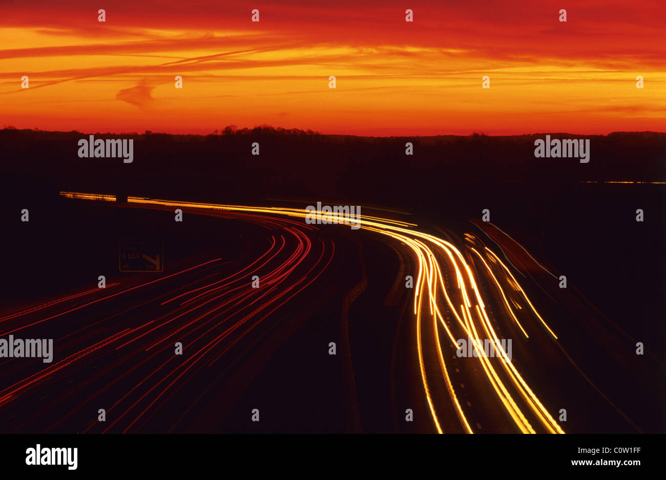 headlight trails of traffic travelling on the M1 motorway at sunset ...