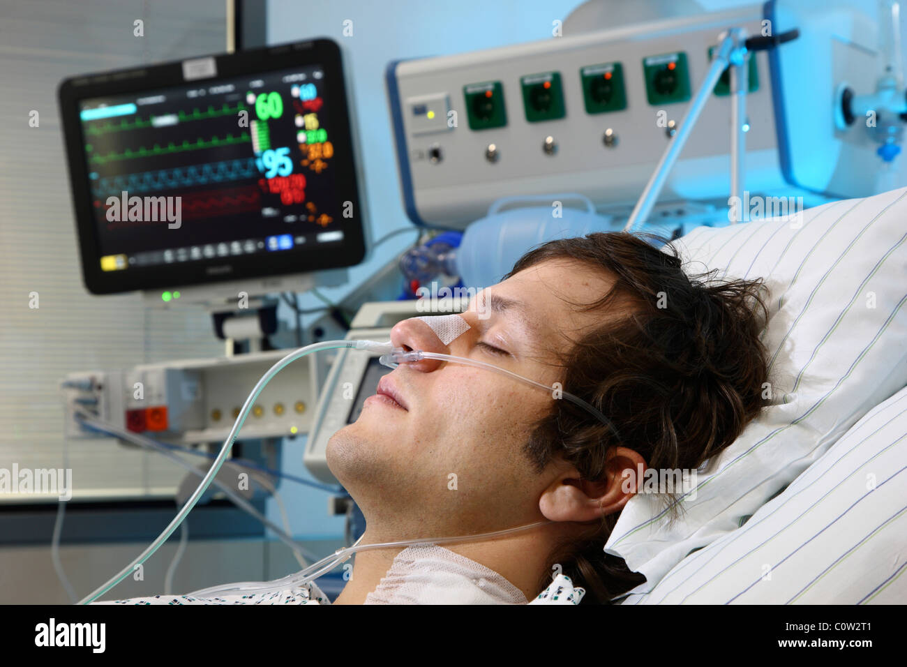 Intensive care unit in a hospital. A patient is connected to different ...