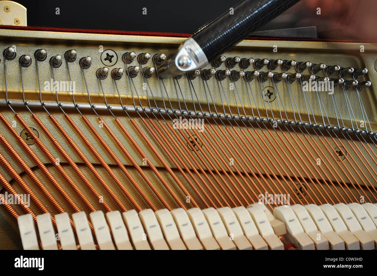 Adjusting the strings tension with a tool Stock Photo - Alamy