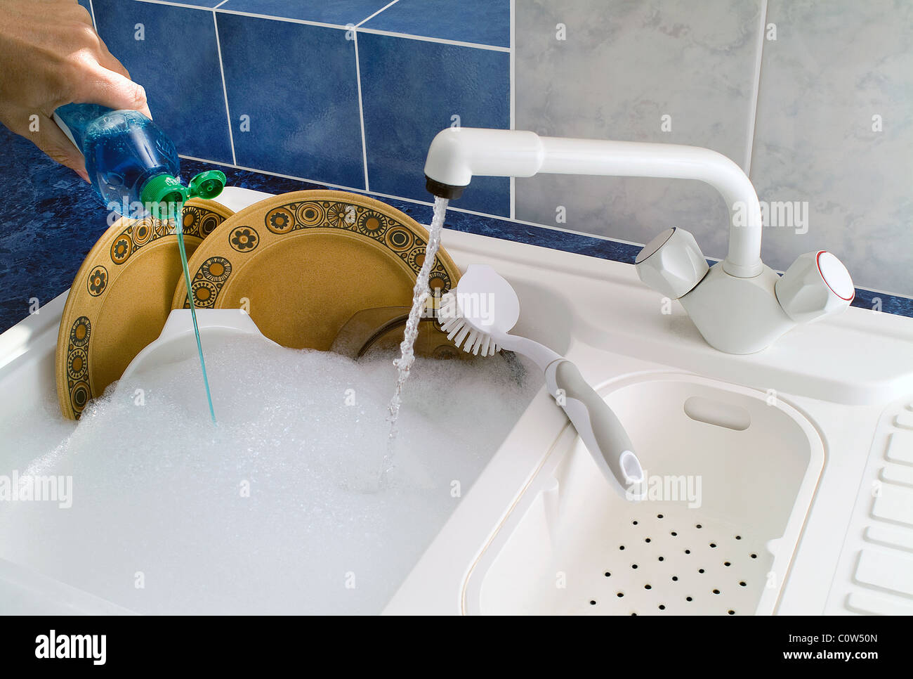 House husband washing dishes in the kitchen sink hi-res stock ...