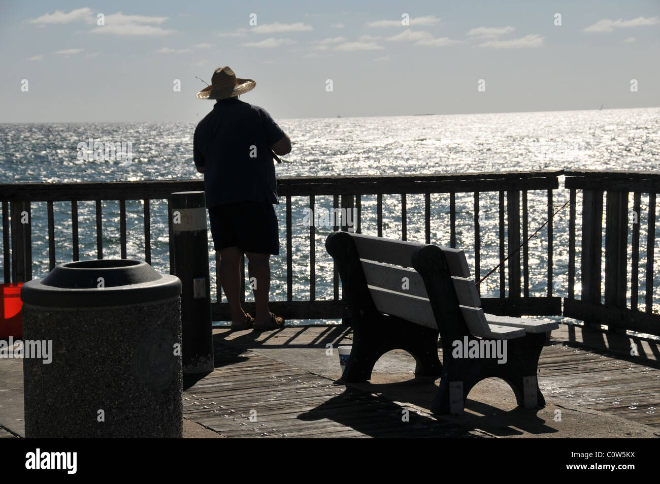 Fishing off the pier in silhouette Stock Photo - Alamy