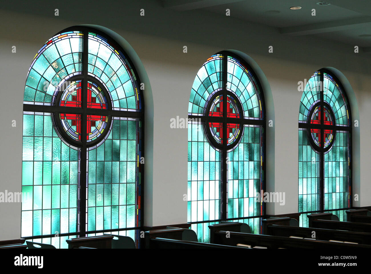 Three stained glass windows are shown from the inside of a church Stock ...