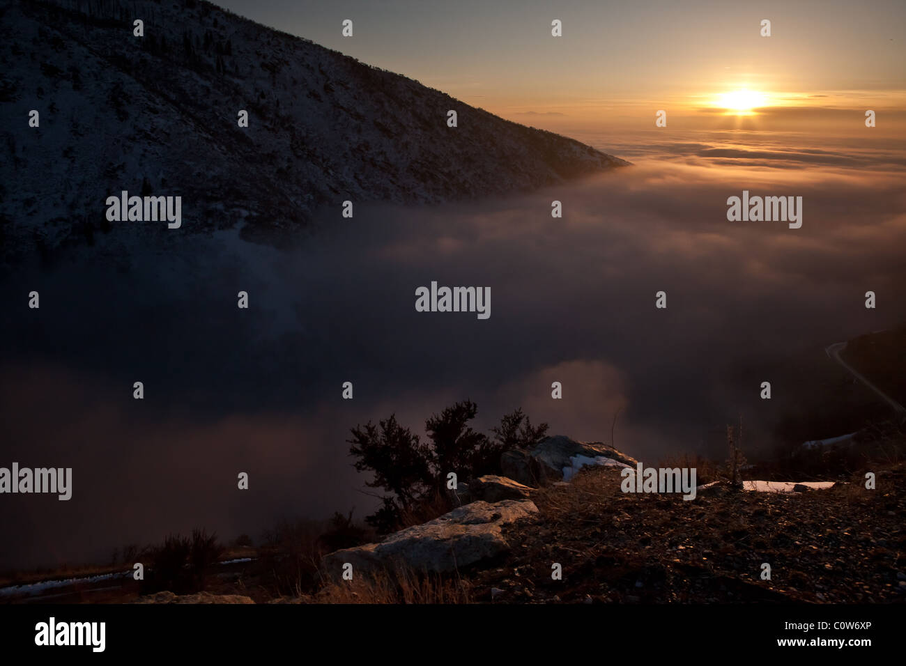 View from above the fog with the sun setting in the distance Stock ...