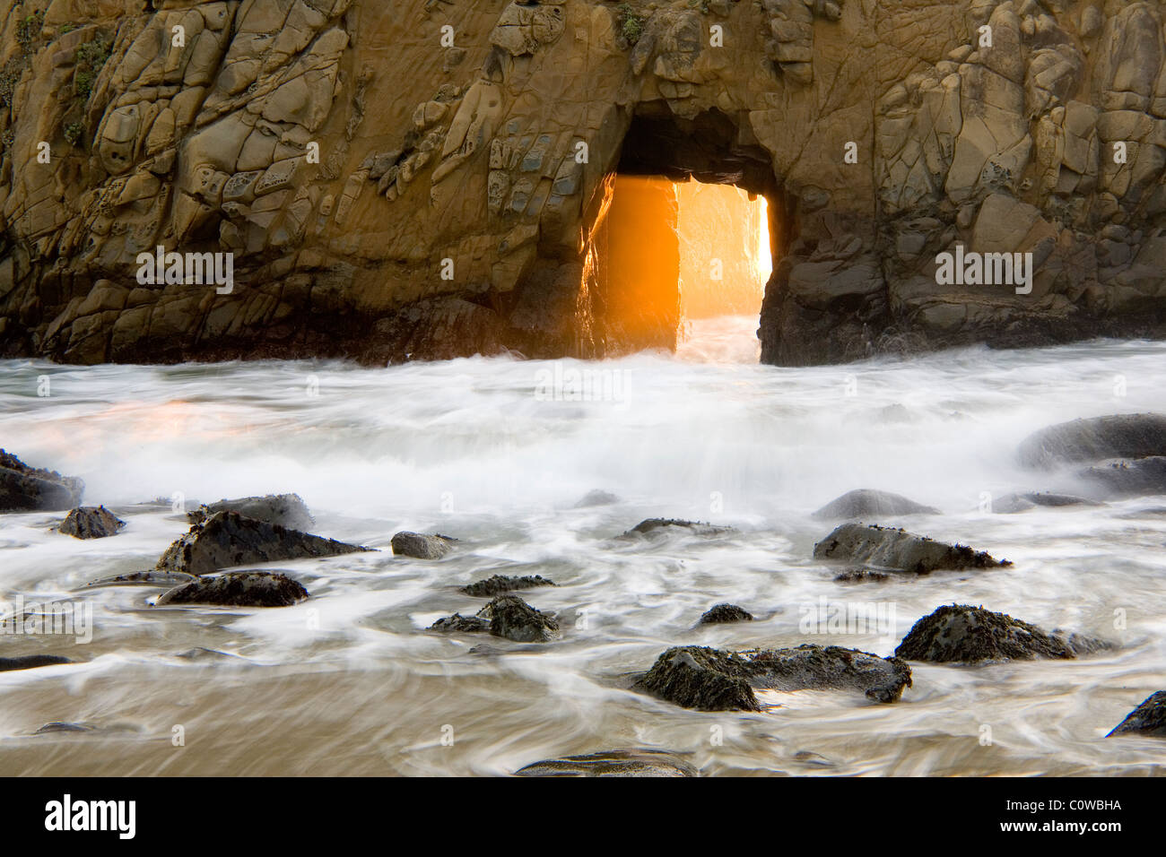 The sun sets through a window to the Pacific, Big Sur Coast, Pfeiffer ...